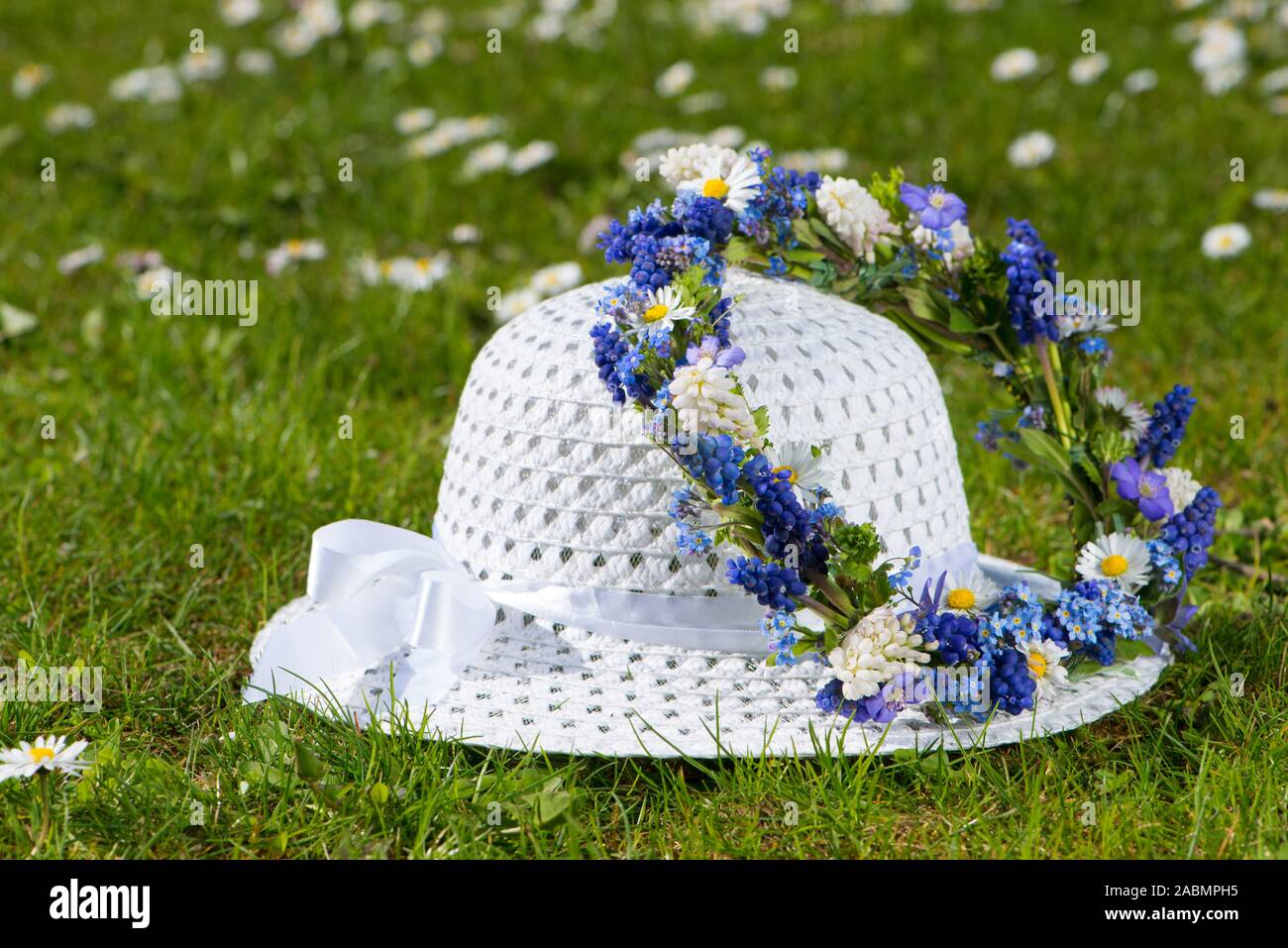 Wreath of spring flowers with a hat Stock Photo - Alamy