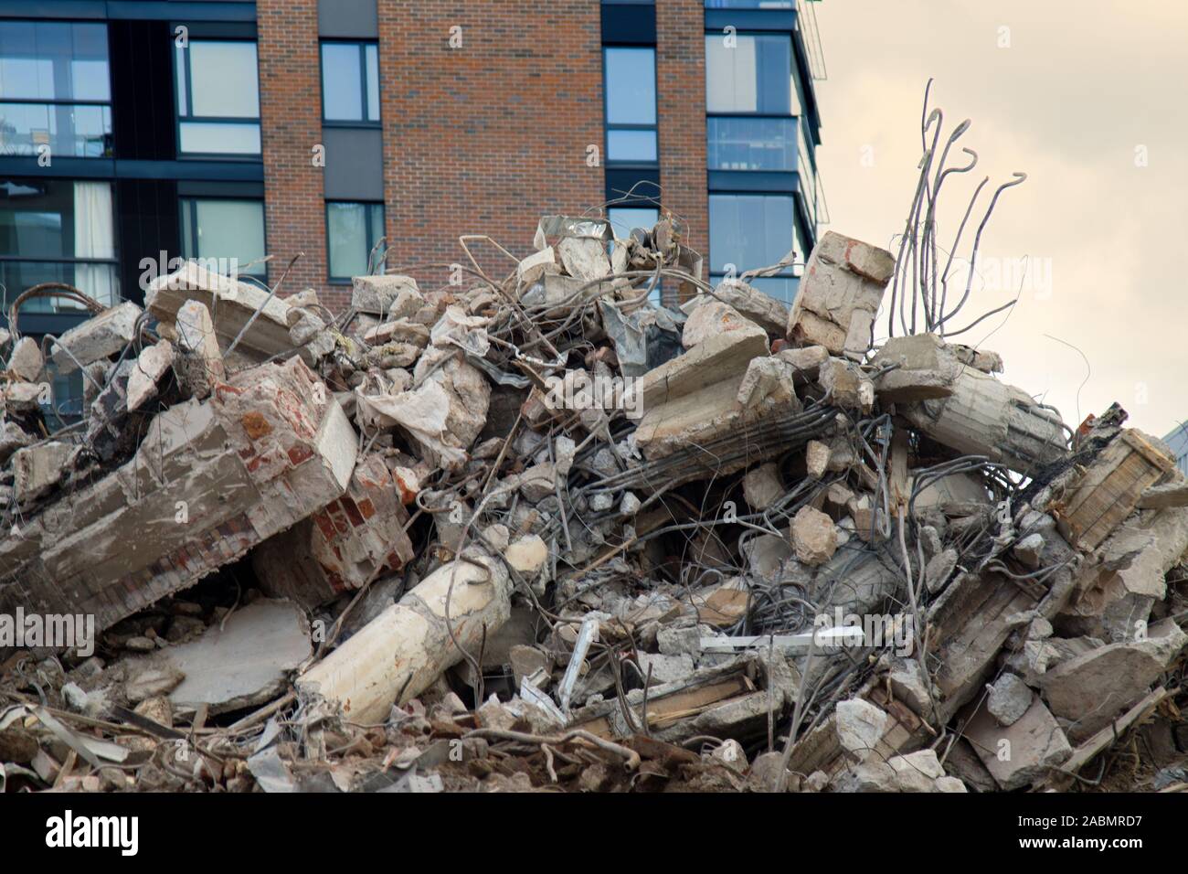 Pile of twisted concrete on background of new building. Urban renewal ...