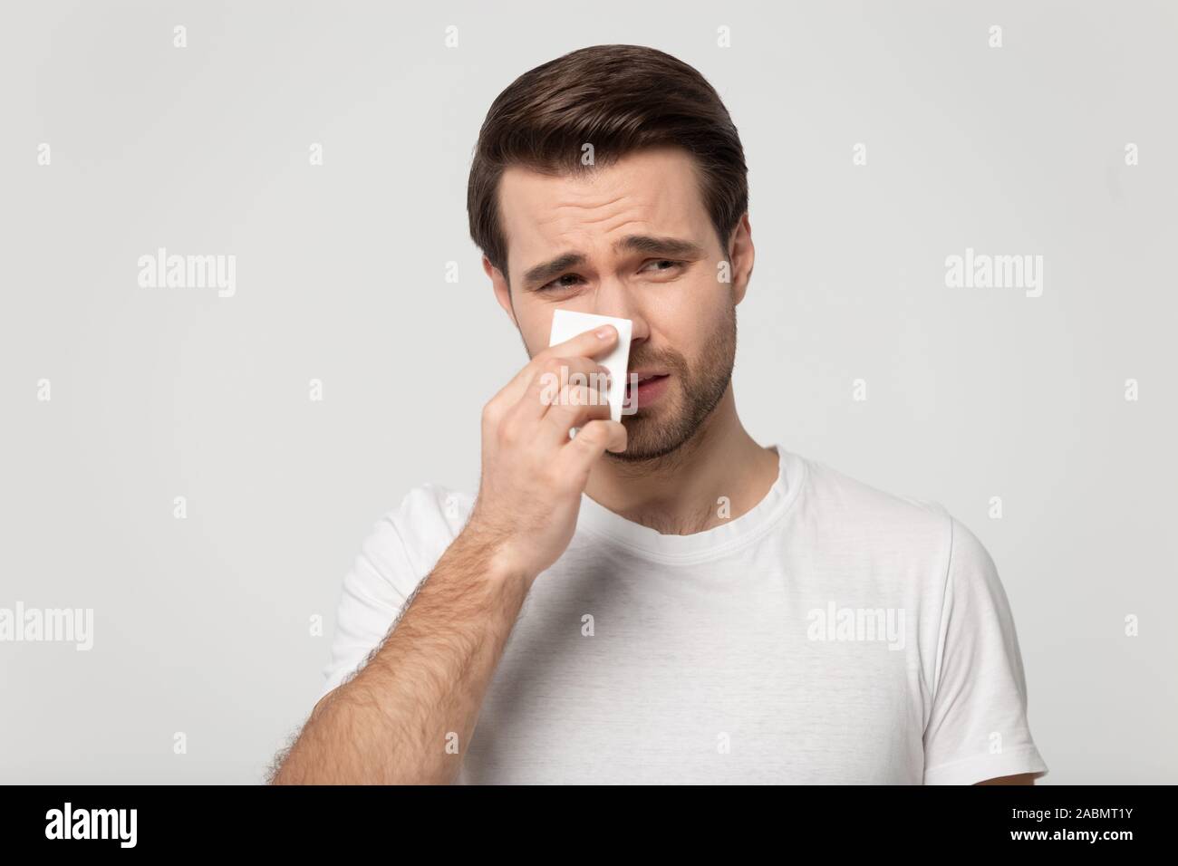 Unhappy young man use paper tissue feeling unwell Stock Photo - Alamy