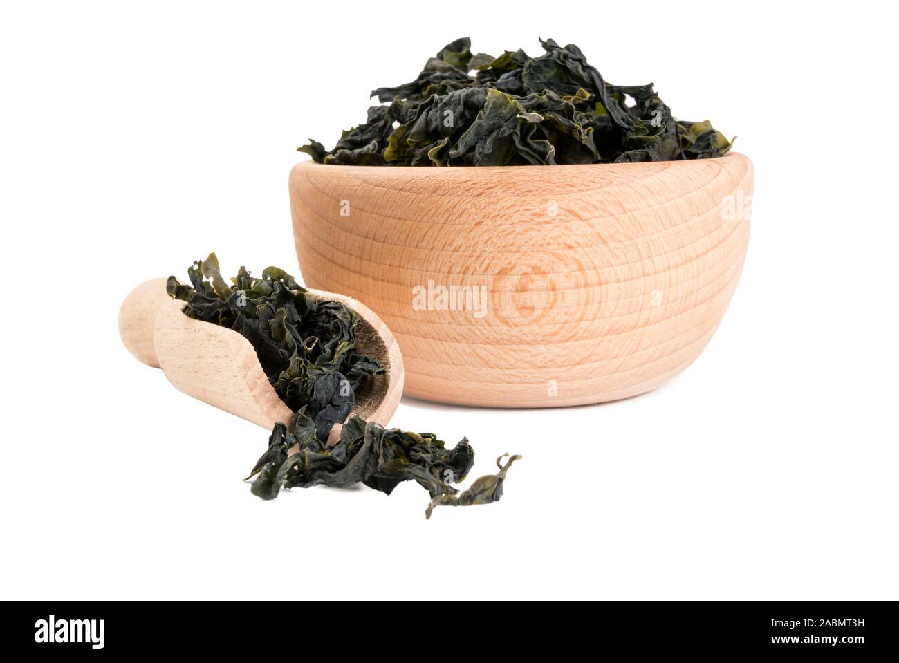 Dried kombu seaweed in wooden bowl and scoop isolated on white ...