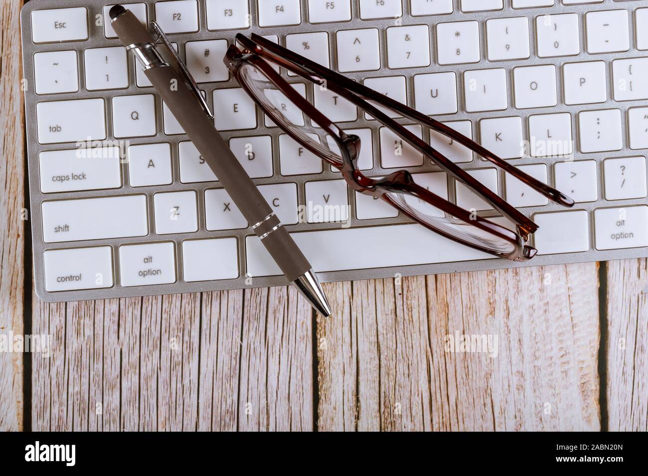 Workplace office desk of reading glasses and pen on the computer ...