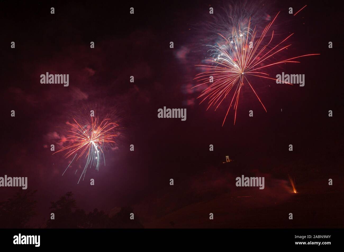 Beautiful couple of azure and red fireworks over trees silhouette Stock ...