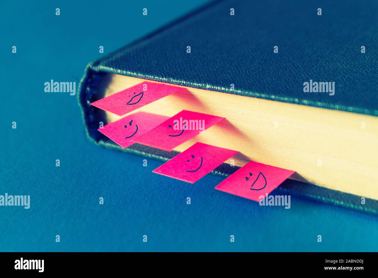 Book with many bookmarks inside it on blue background Stock Photo - Alamy