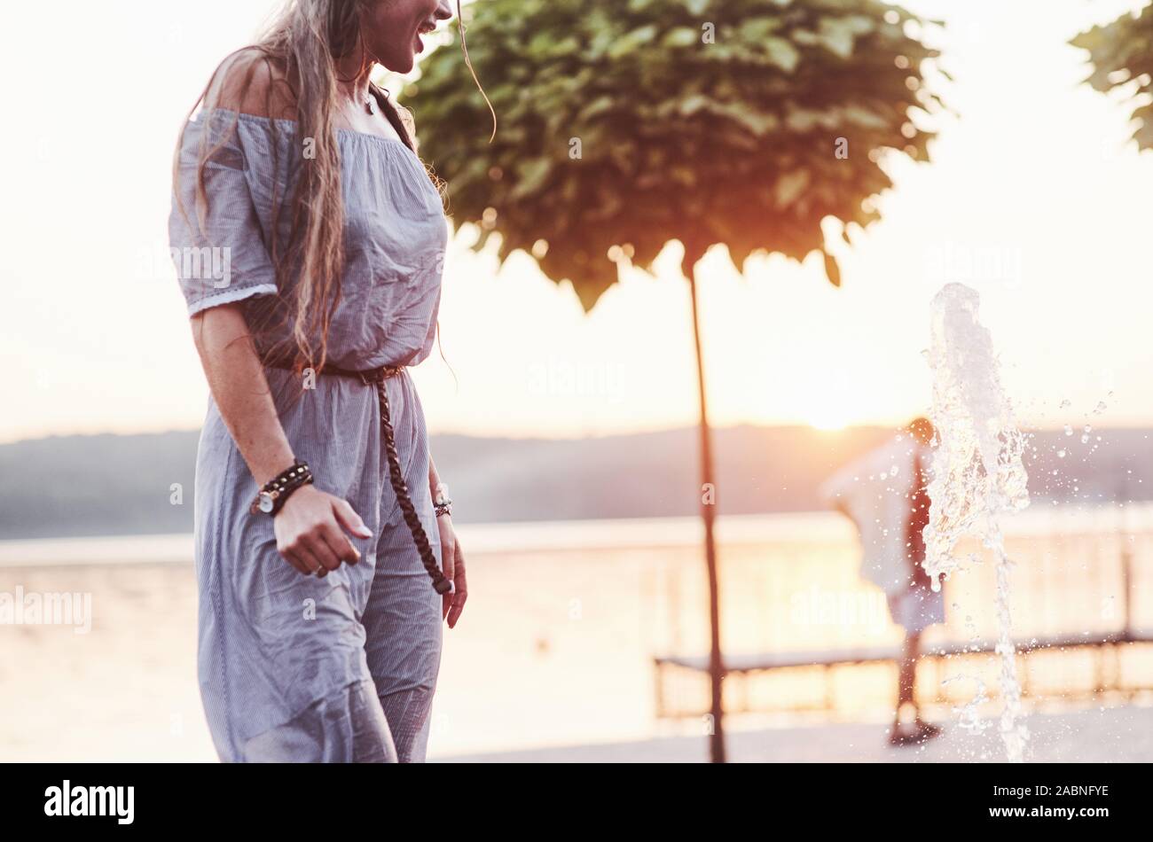 Wet adult woman enjoying cooling by the water at hot day Stock Photo ...
