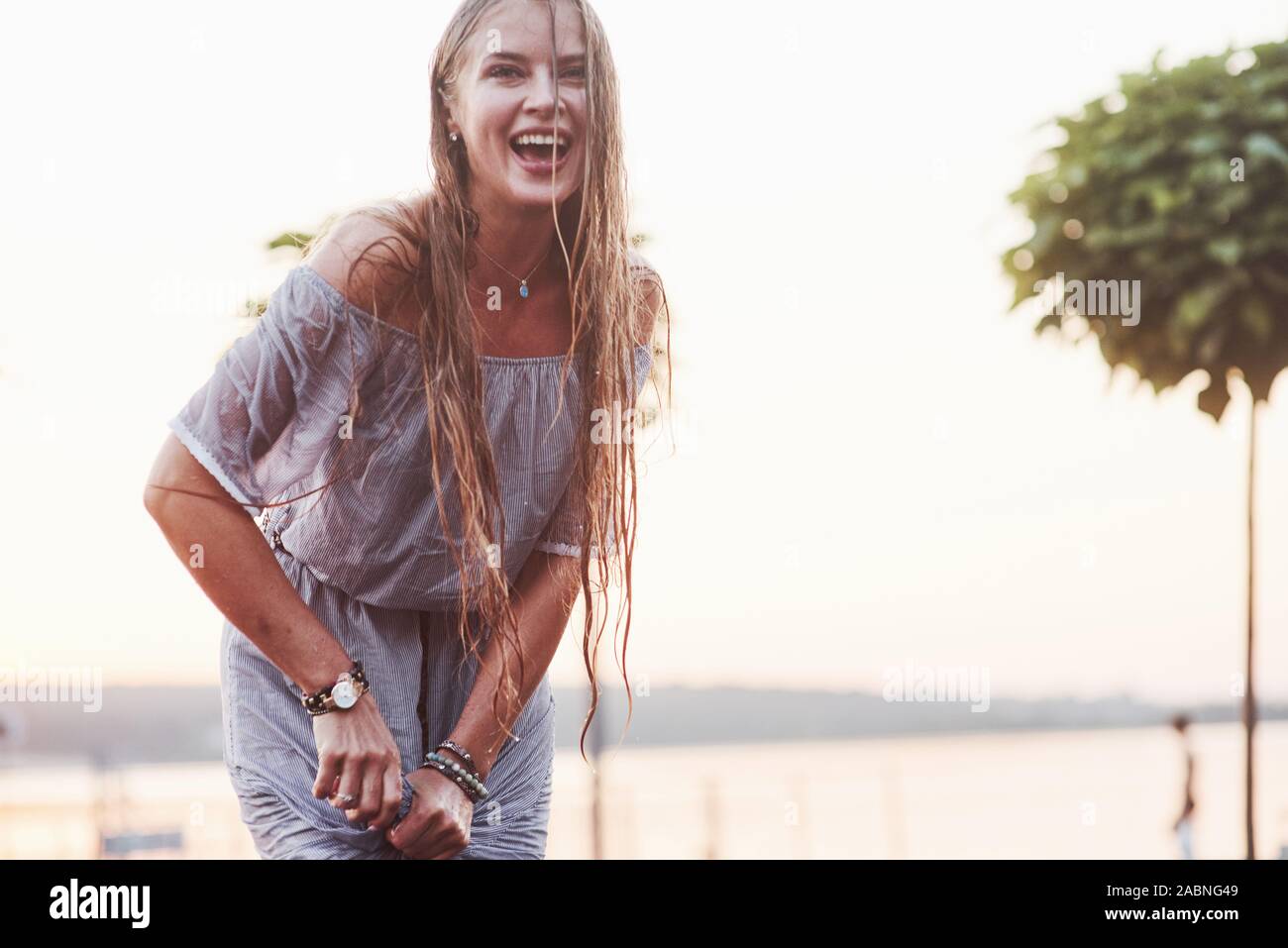 Women refreshing herself in sunny hot day with fountain at background ...