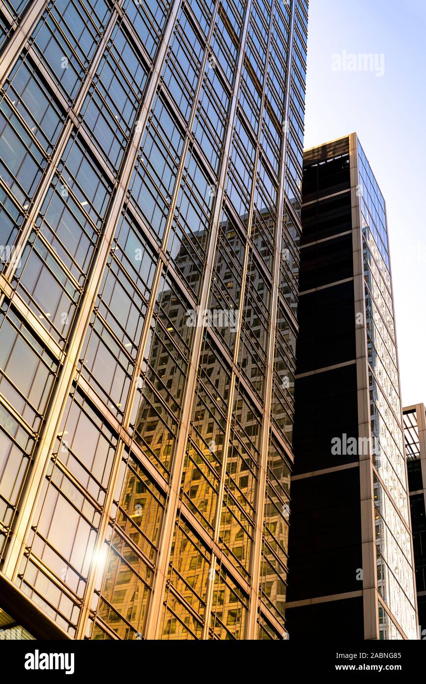 Modern city sky scrapers with glass fronts on a clear day at sunset in ...
