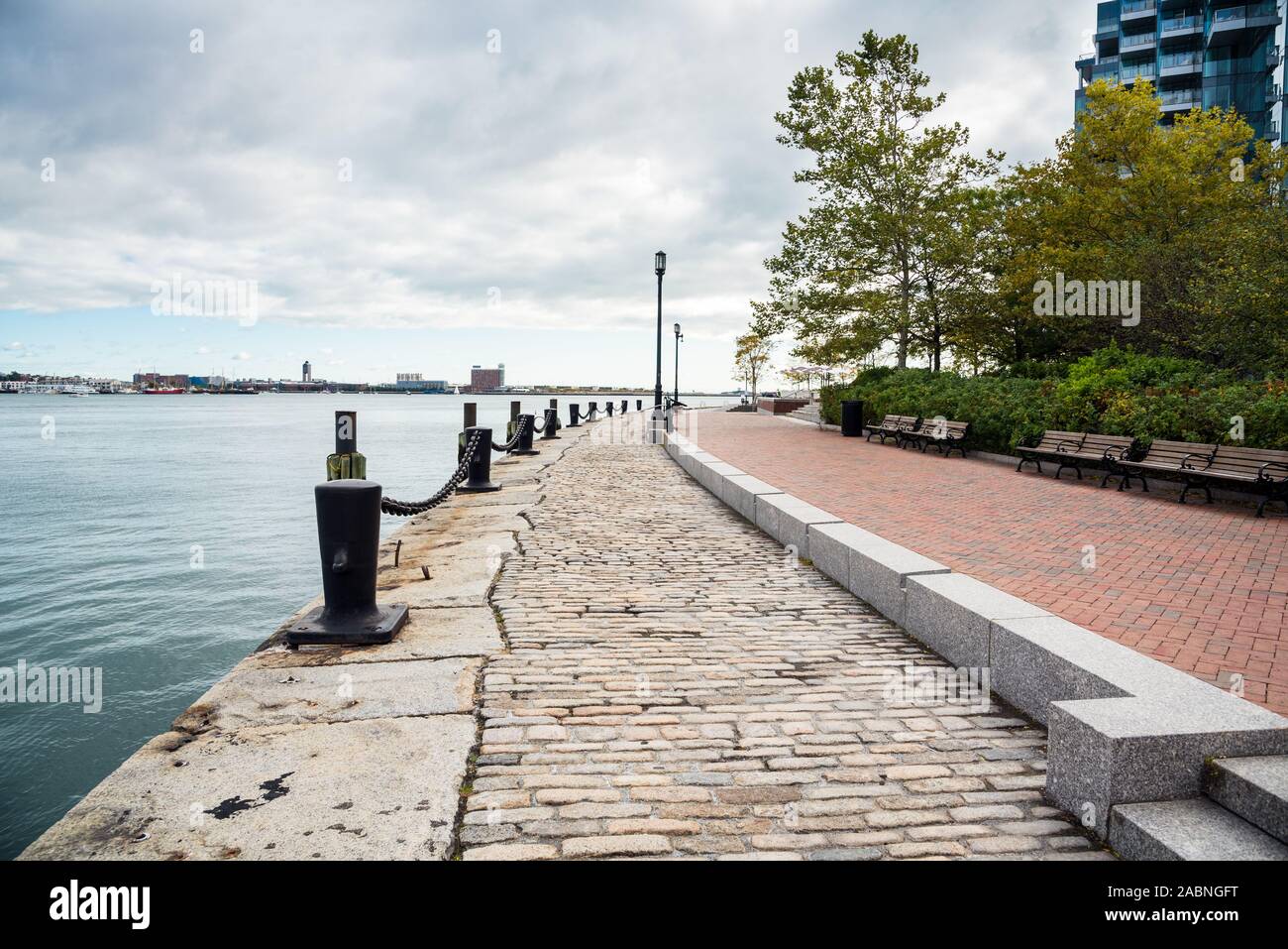 Empty Cobblestone path running alongside a harbour on a cloudy autumn ...