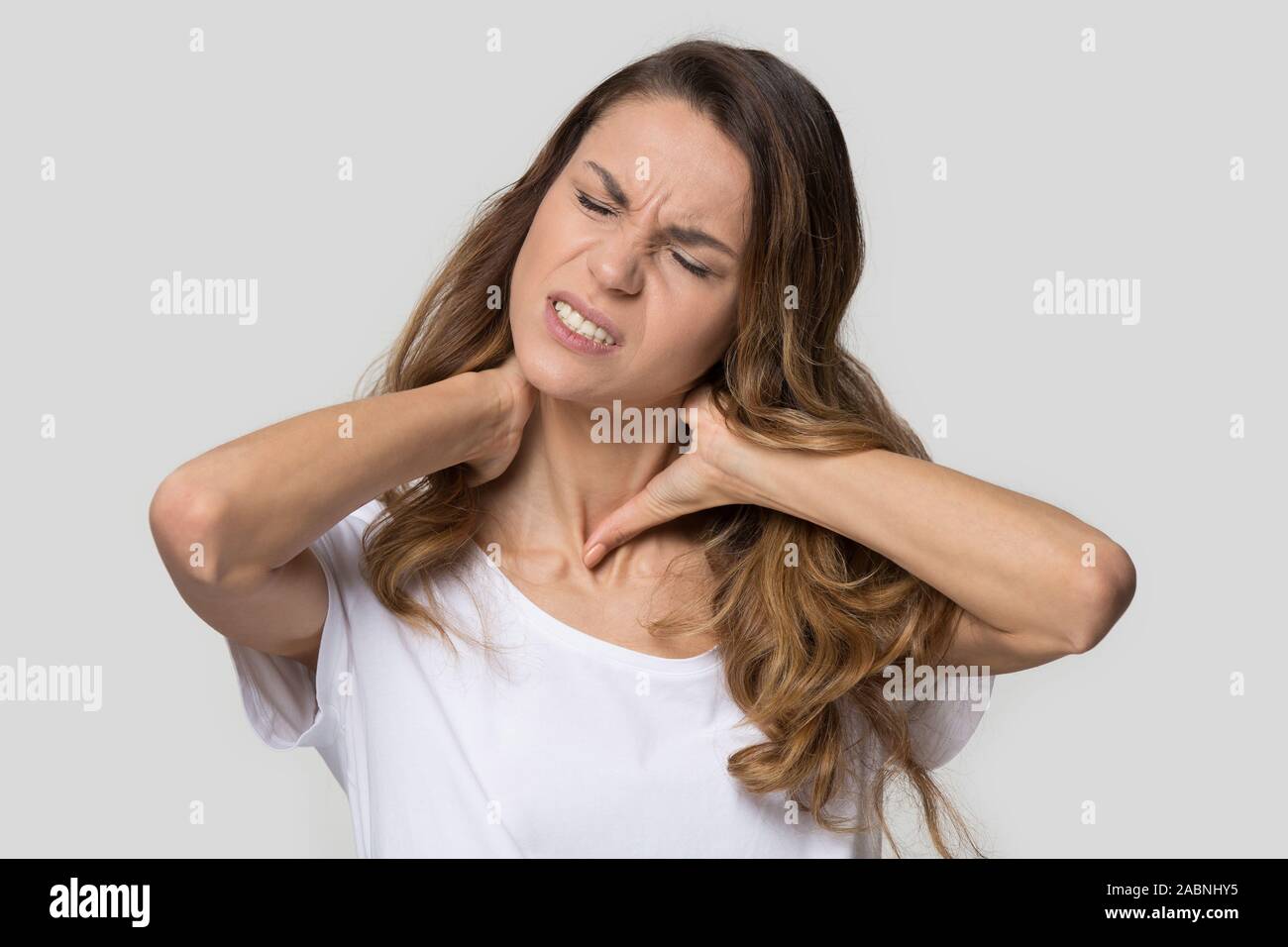Tired exhausted young woman massaging tensed neck muscles Stock Photo ...