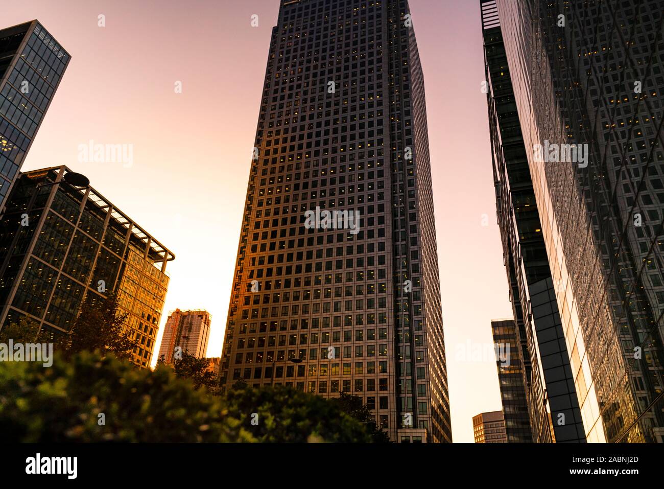 Modern city sky scrapers with glass fronts on a clear day at sunset in ...