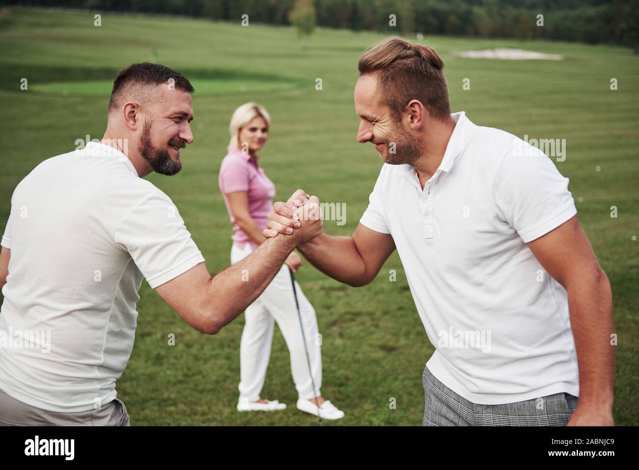 Three players play on the golf course. The team congratulates and ...