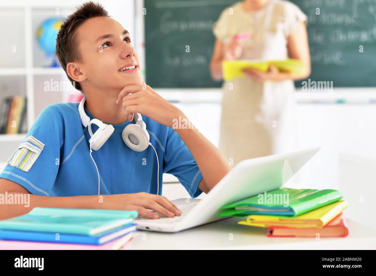 Cute boy using laptop in class room Stock Photo - Alamy