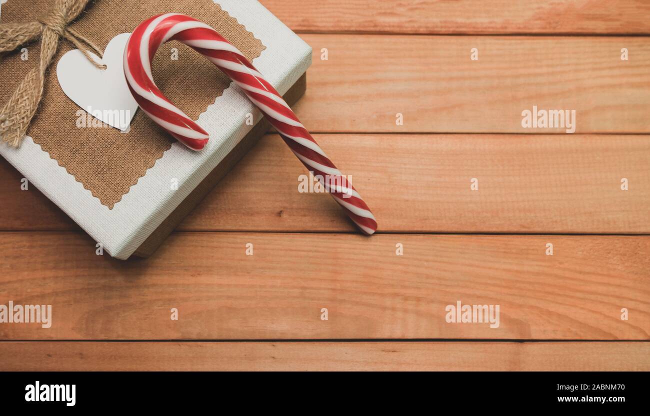 Beautiful striped hard candy cane staff on a wooden table background ...