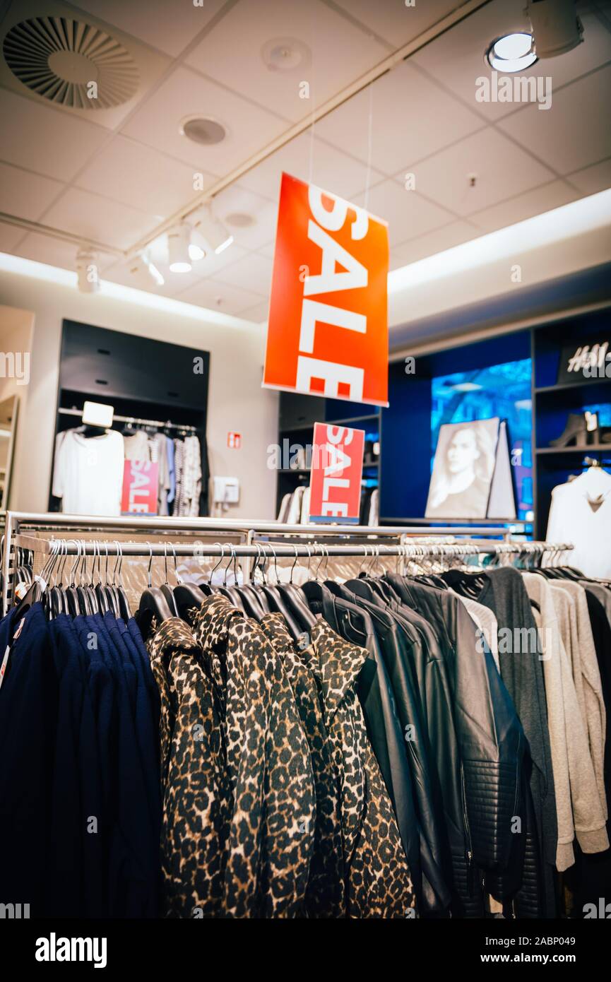 Red sale tag above multiple clothes in modern fashion store Stock Photo ...