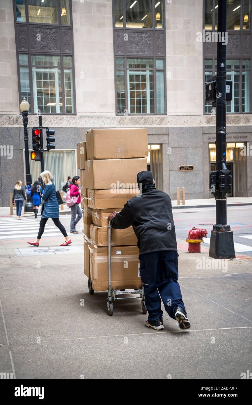 Delivery man pushing cart full of boxes, Chicago, Illinois, USA Stock ...