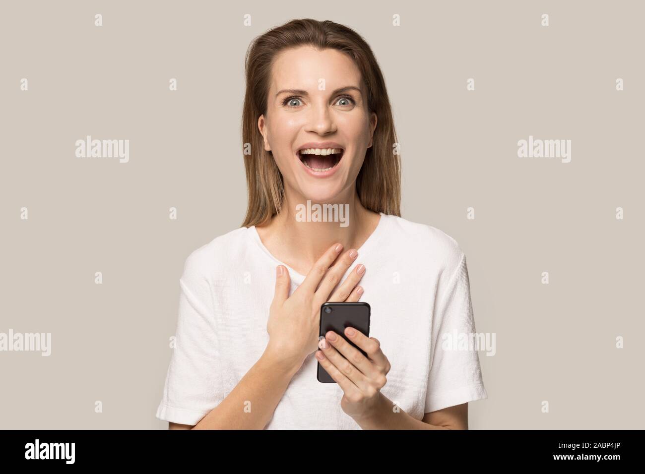 Woman holding phone happy reaction hi-res stock photography and images ...