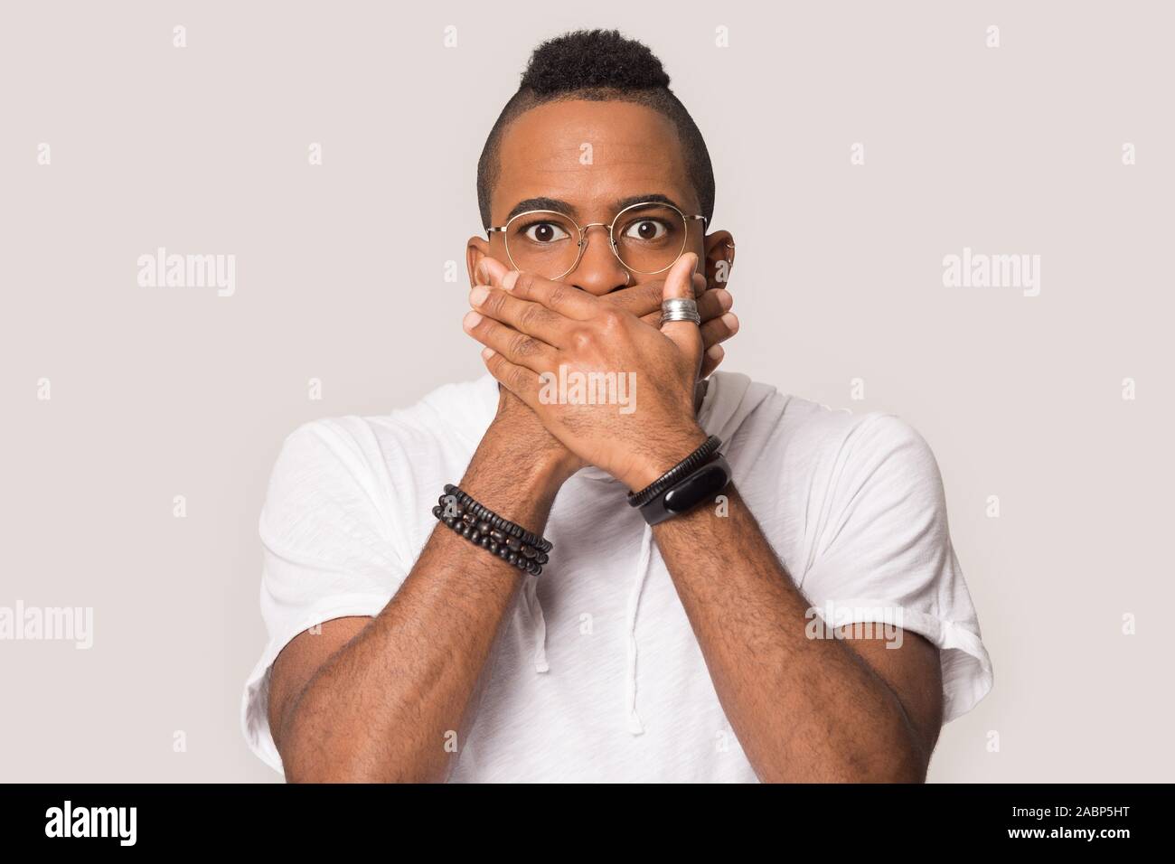 Shocked scared African American man covering mouth with hands Stock ...