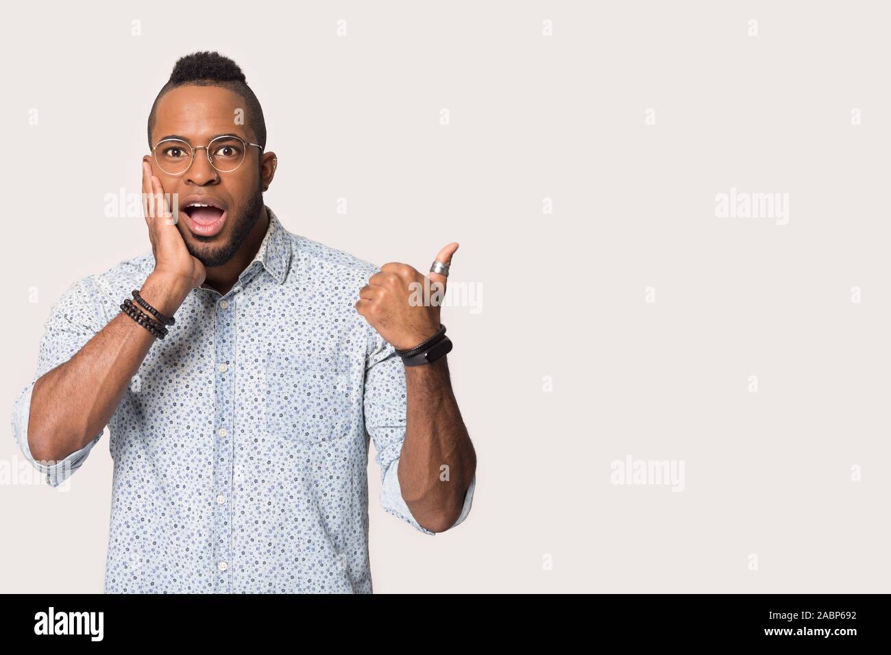 Amazed African American man pointing finger at copy space isolated ...
