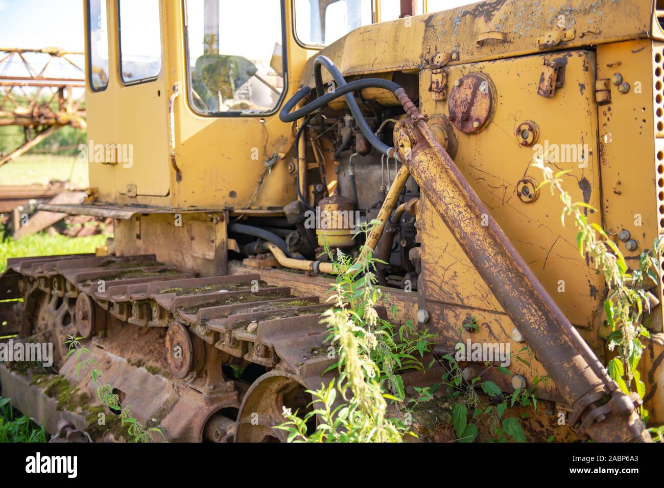 Abandoned farm equipment. The bulldozer covered with moss. Overgrown ...