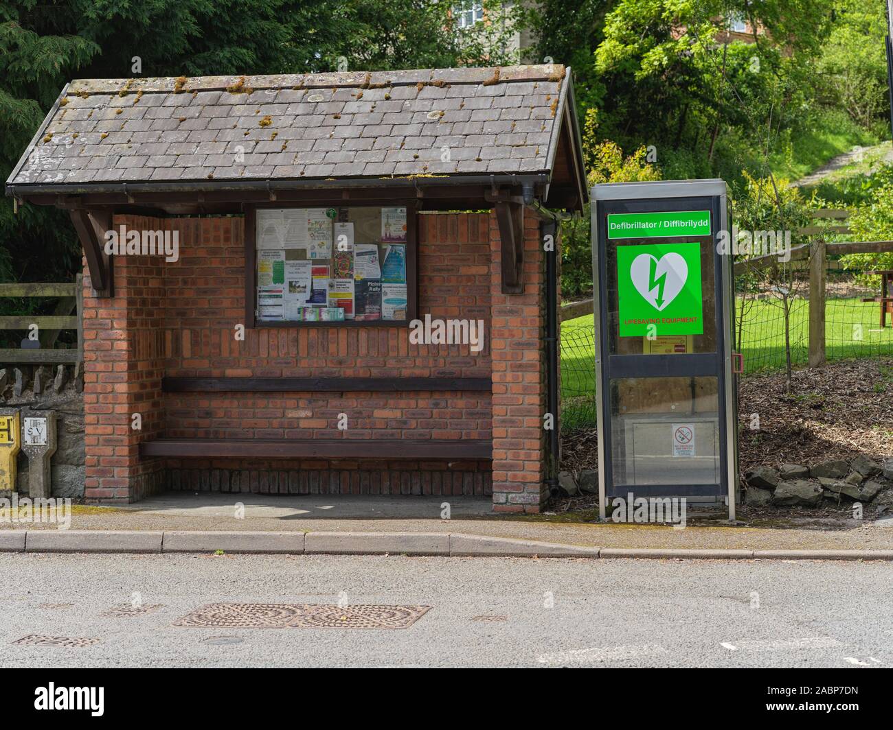A bus shelter with a notice board next to an old telephone box now ...