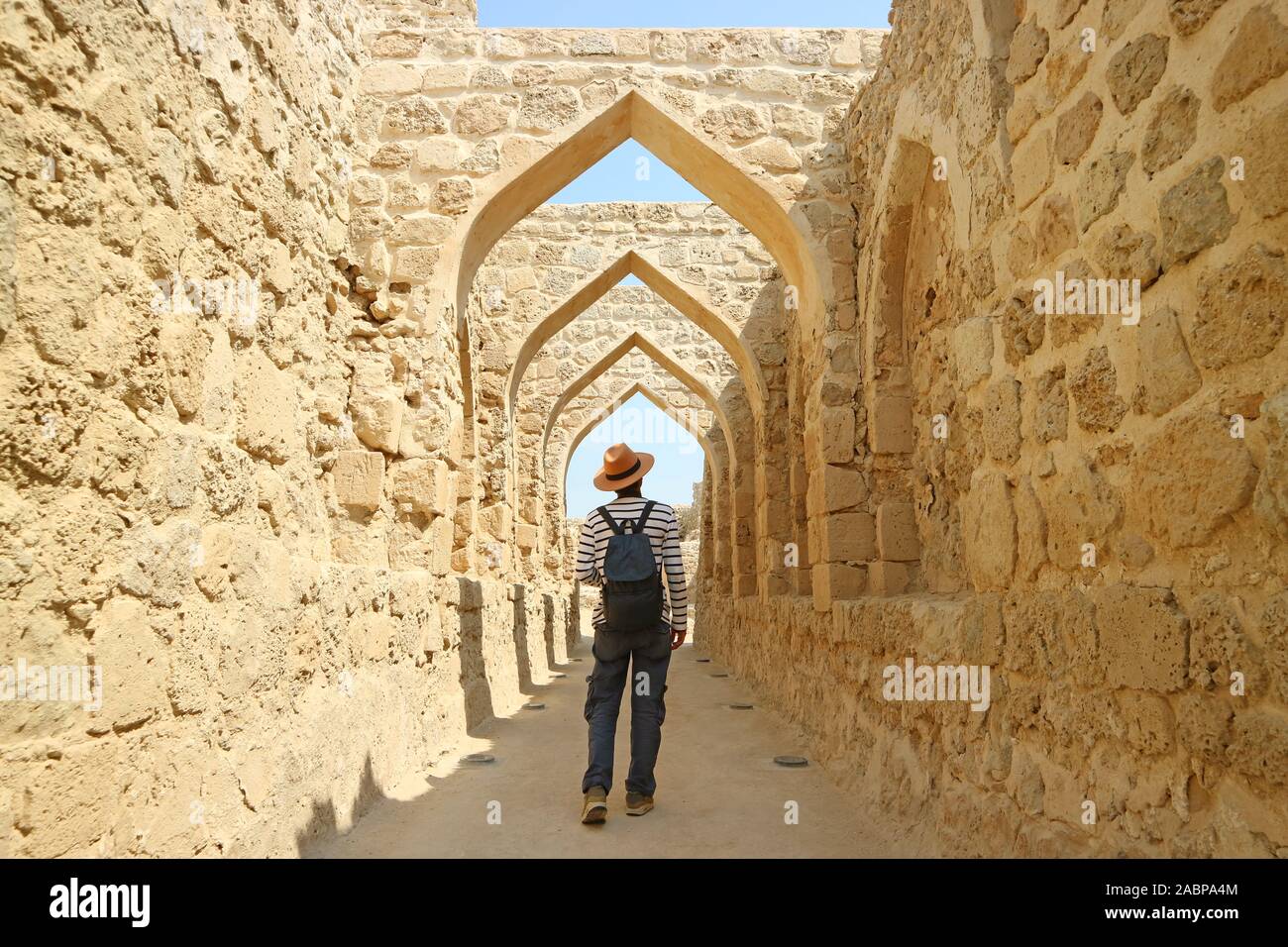 Man Walking Along the Iconic Archways in Bahrain Fort, Manama, Bahrain ...