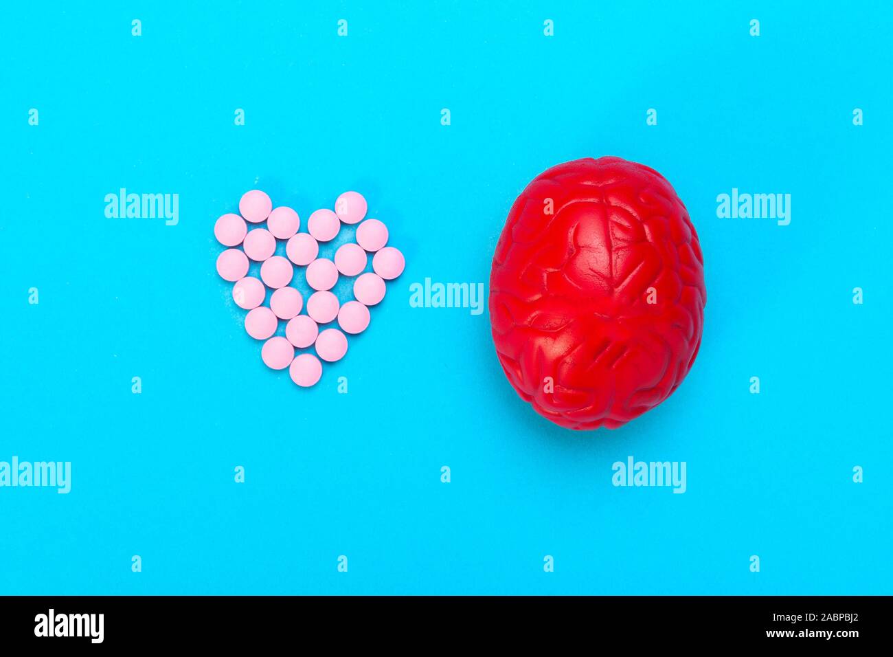 Red brain on a blue background with pink pills. Some pills for the ...