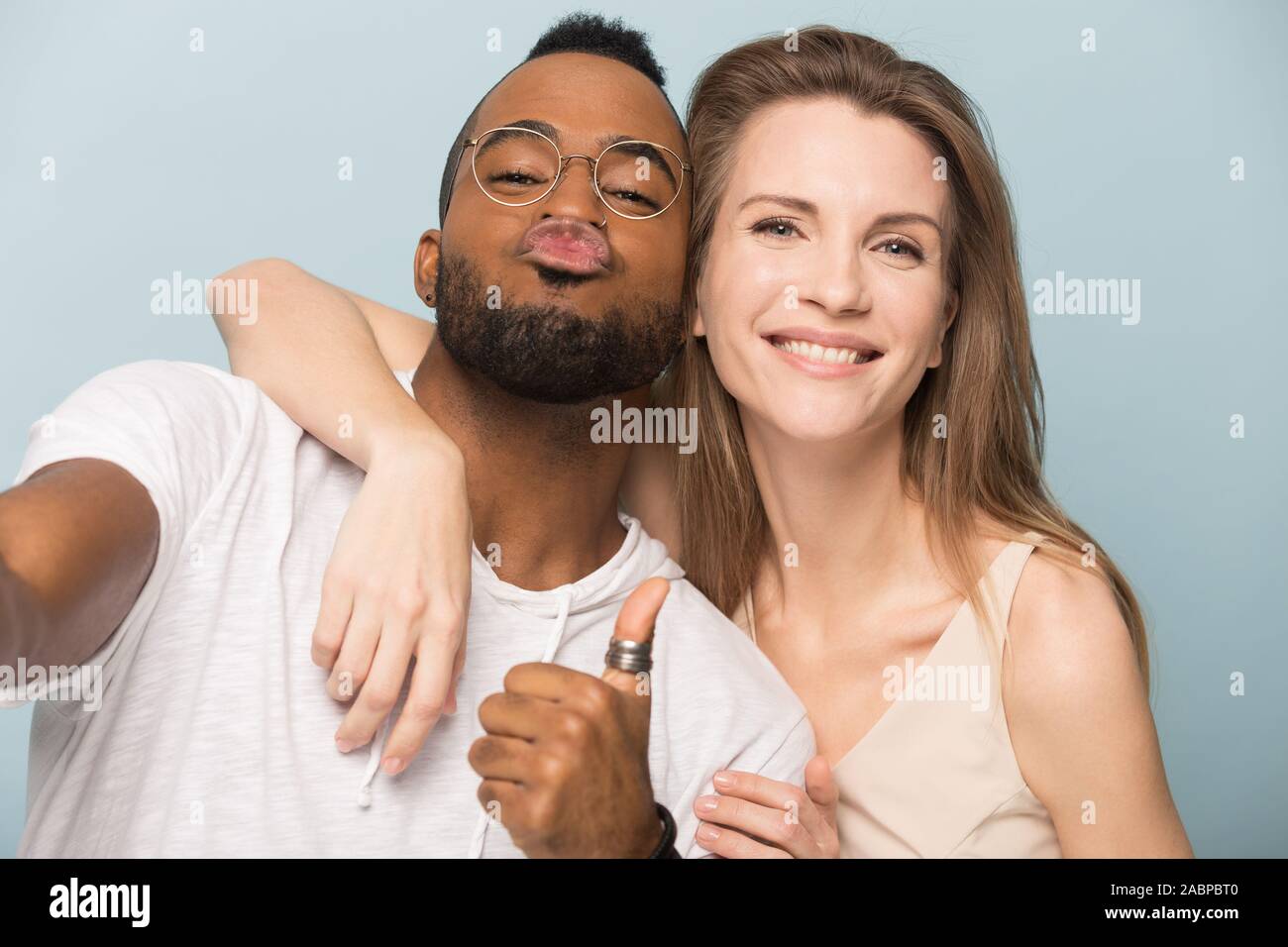Funny African American man and Caucasian woman taking selfie together ...