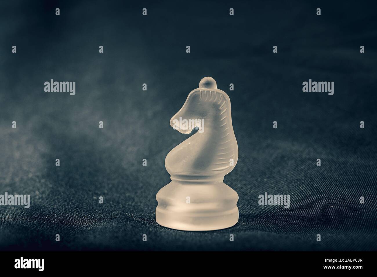 forsted white glass knight chess piece on dramatic background Stock ...