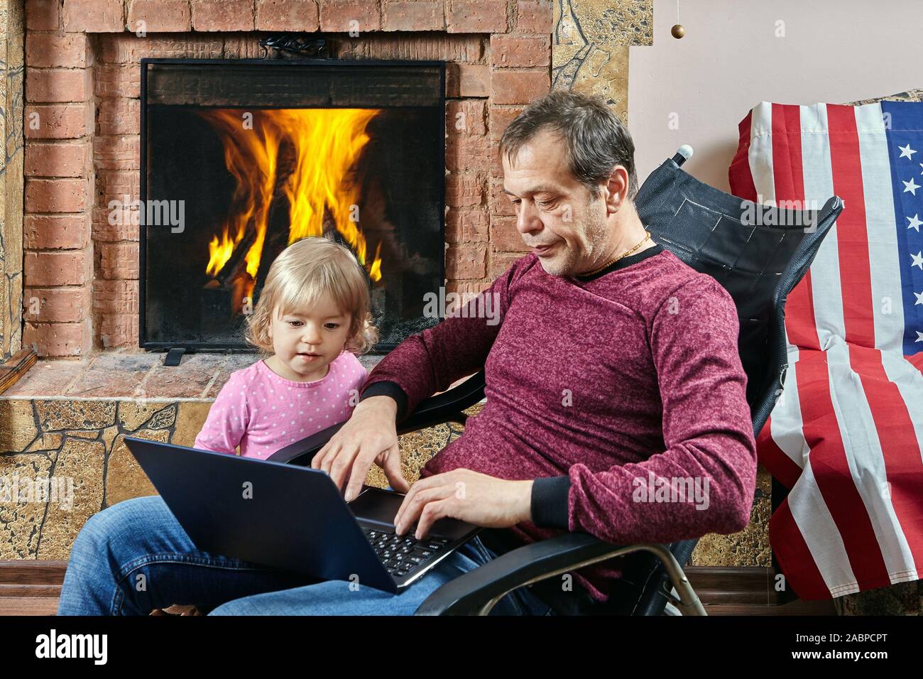 Serious mature father are showing laptop to his curious little daughter ...