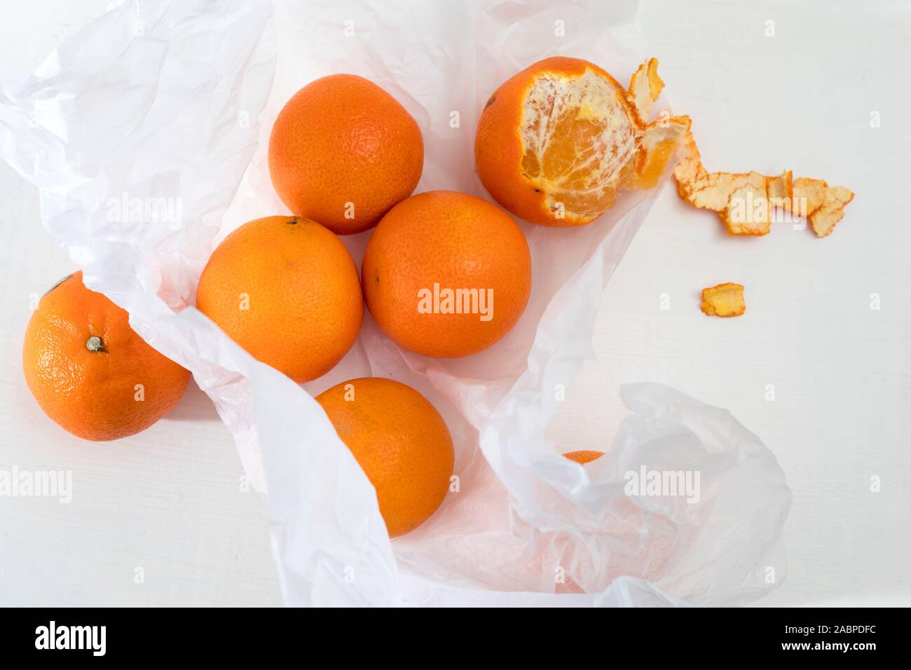 Tangerines in yellow crumpled craft paper on a dark wooden kitchen ...