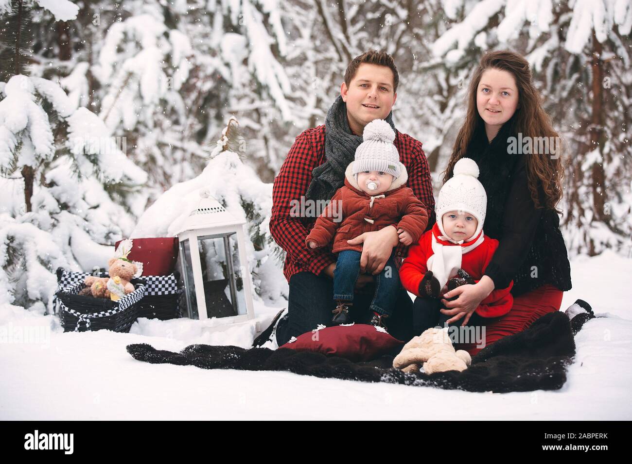 portrait of a stylish family having a good time in the winter forest ...
