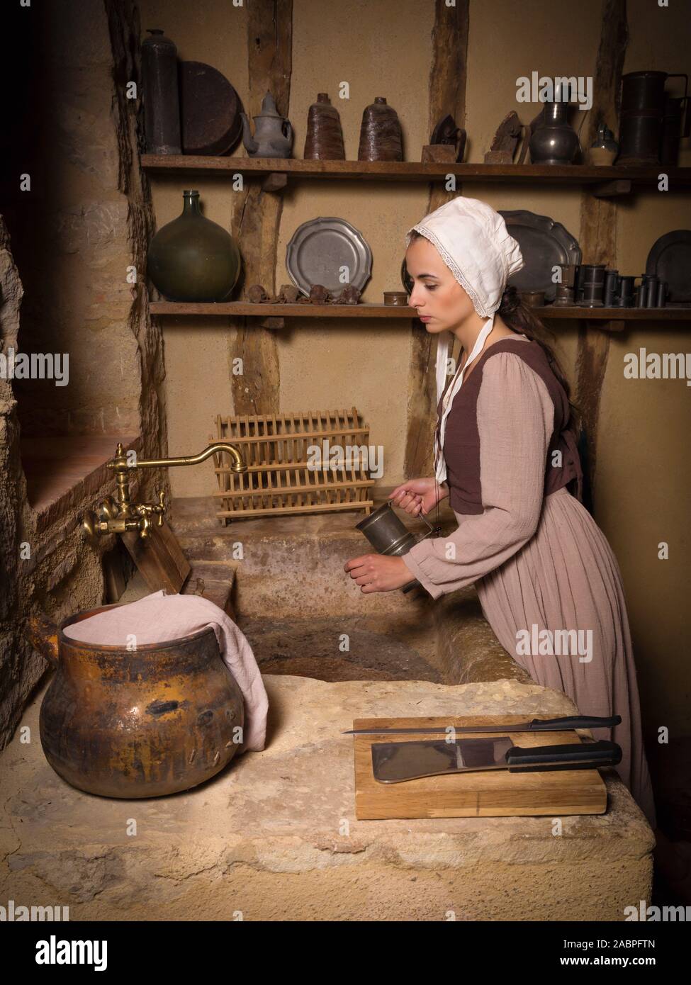 Young woman in Medieval peasant constume working in an authentic ...