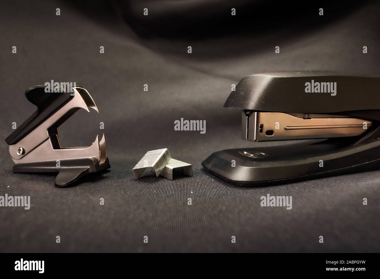 Stapler verses staple remover Office conflict example Stock Photo - Alamy