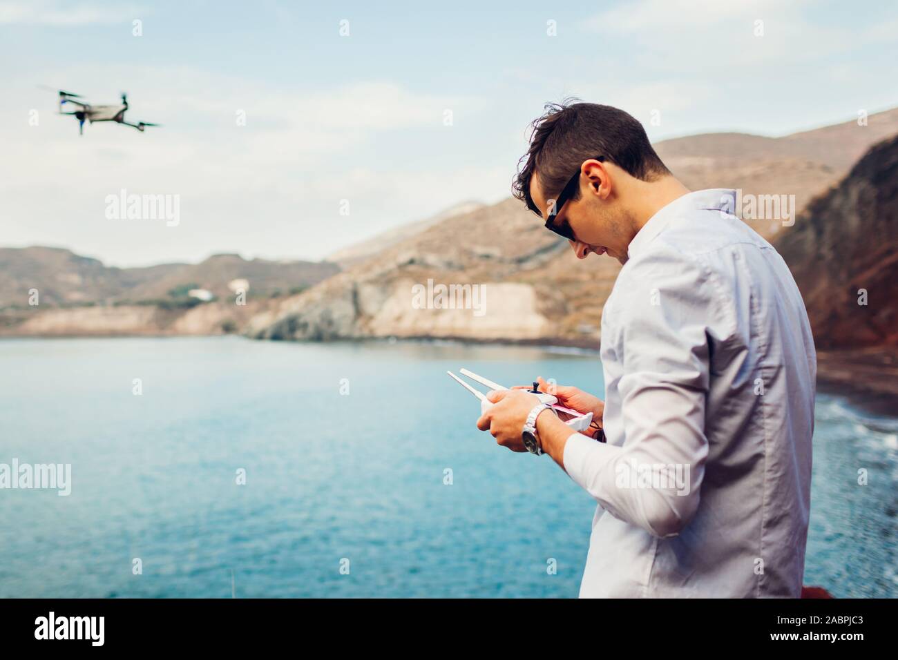 Drone remote control. Man operating copter controller by sea. Aerial ...
