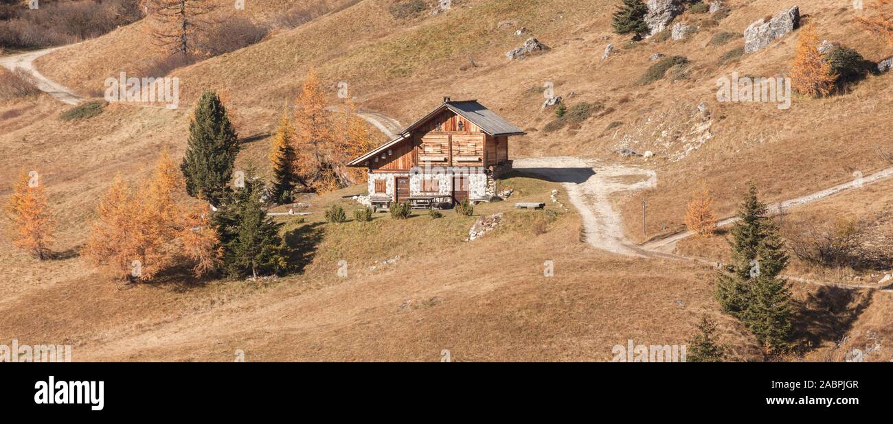 An isolated mountain cabine among yellow pastures in autumn among the ...