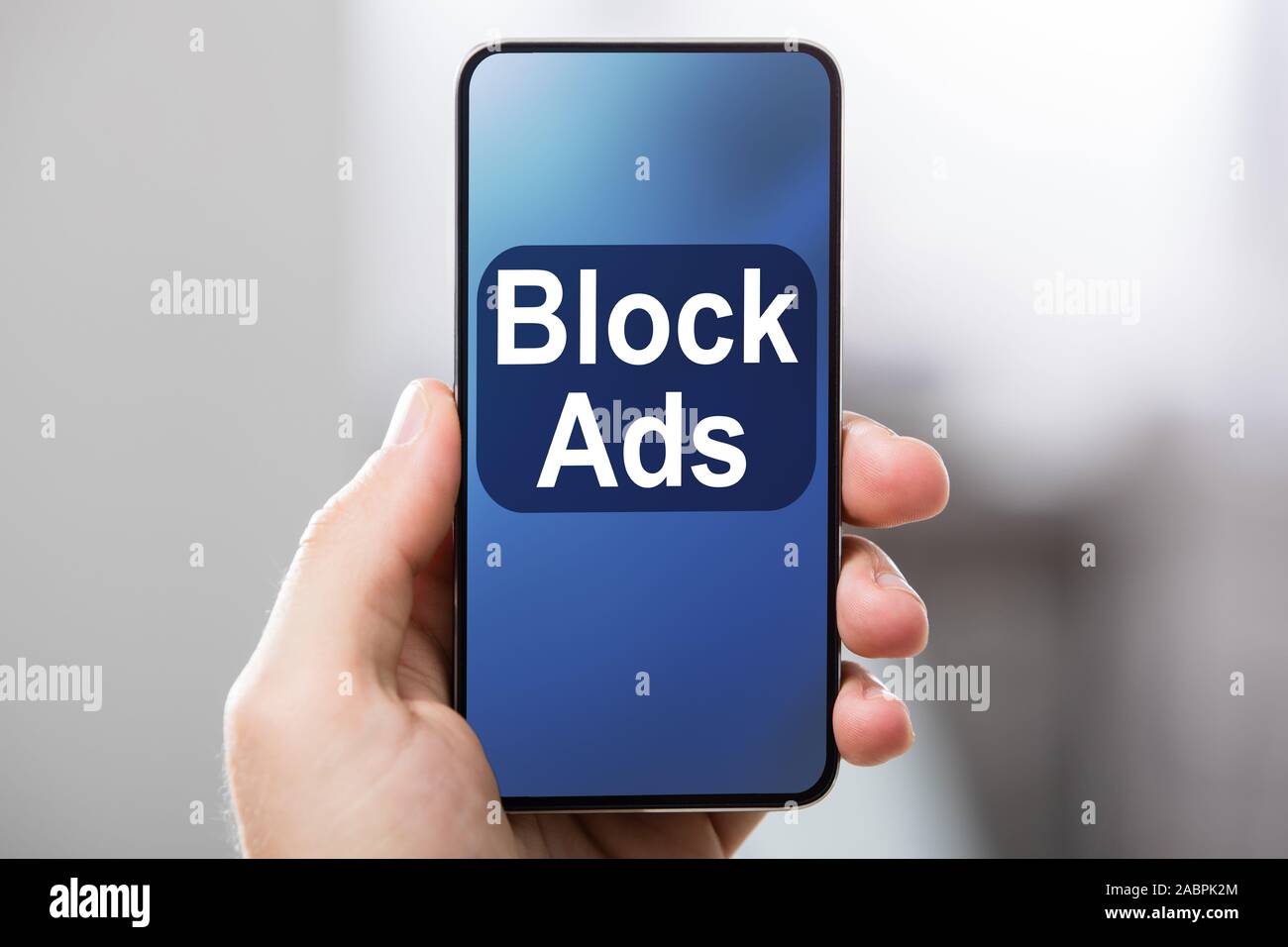 Person's Hand Holding Mobile Phone With Screen Showing Block Ads ...