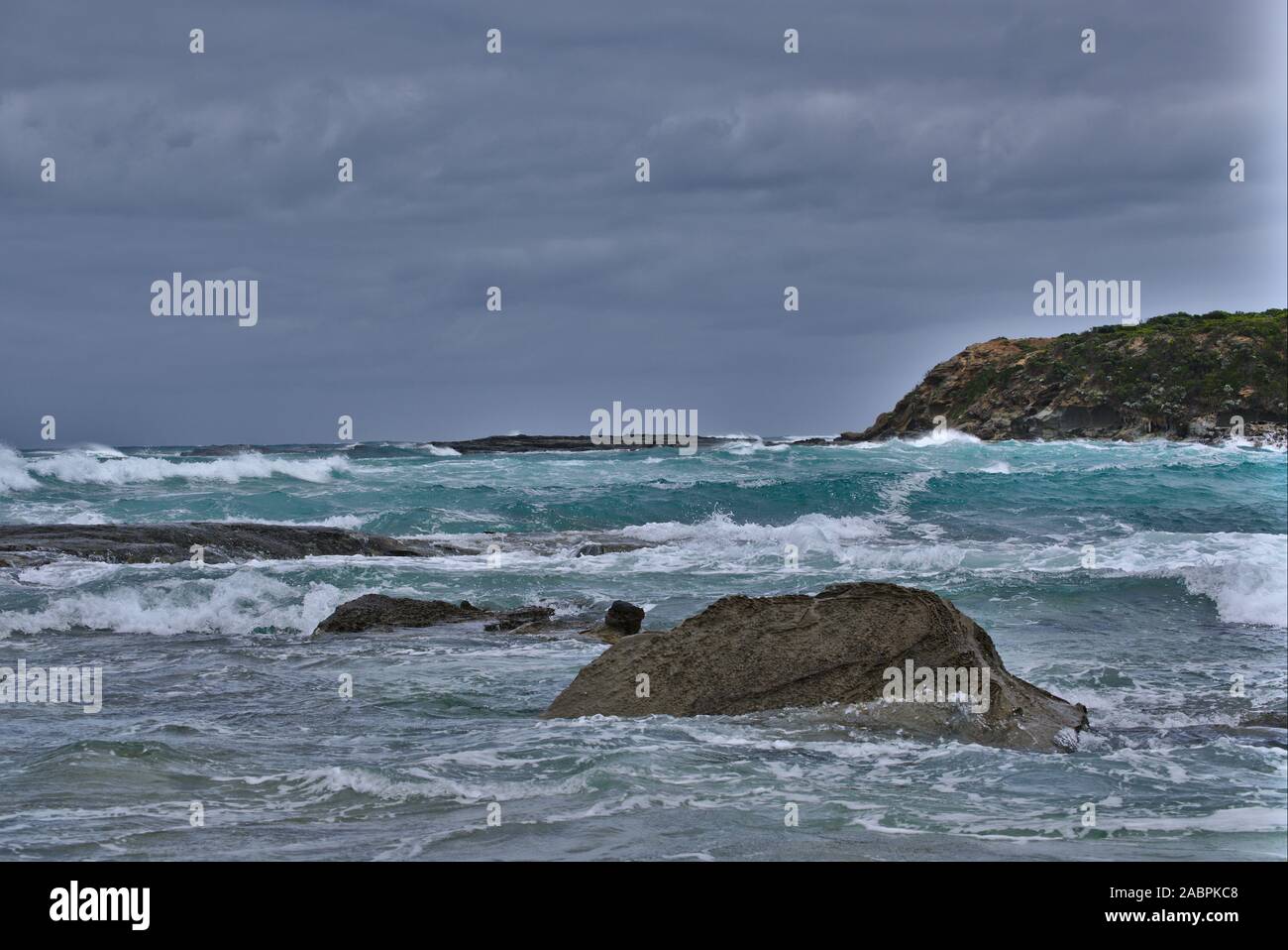 Landscape photo of rough seas with waves crashing into the shore with a ...