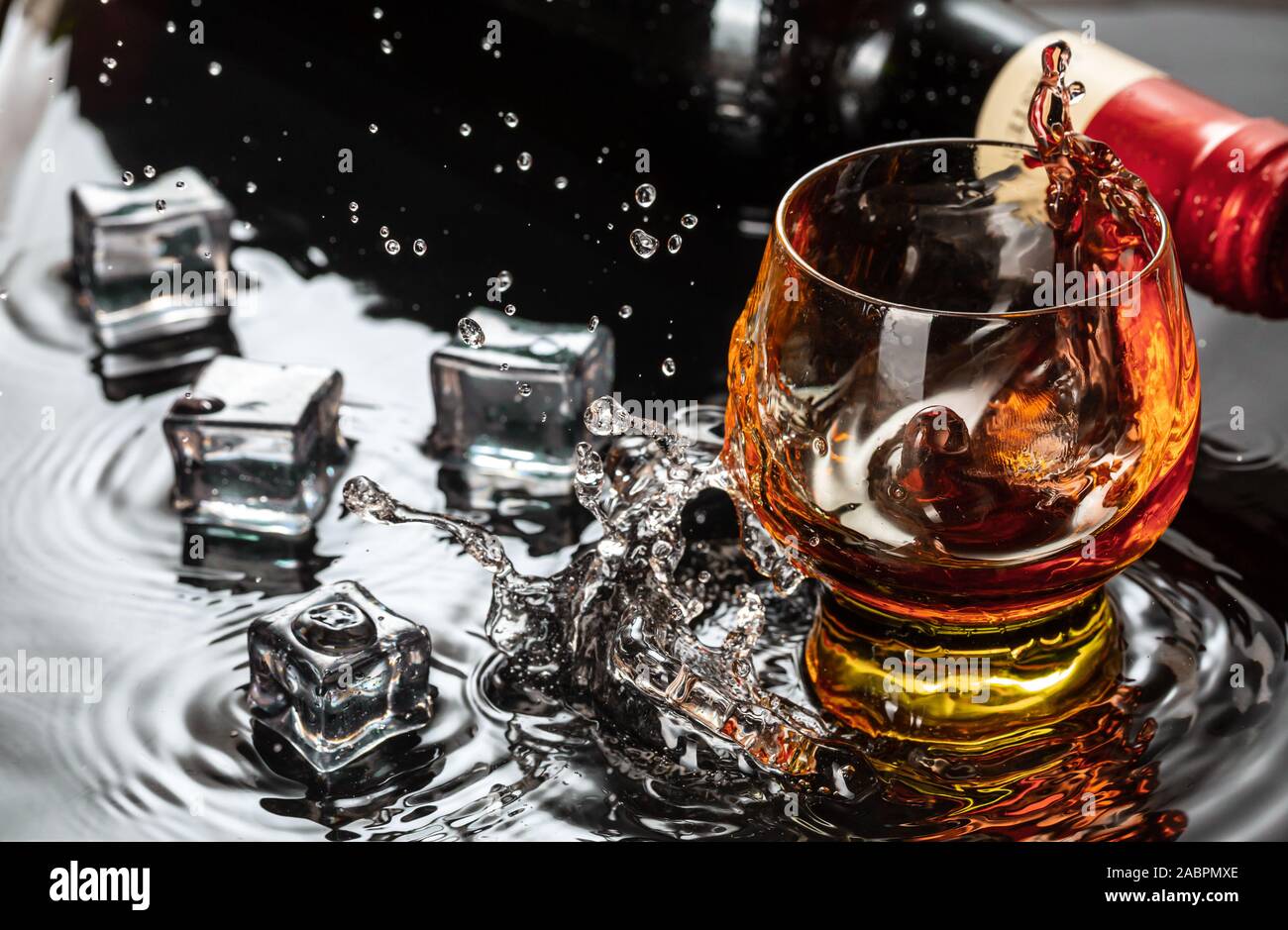 Bottle of red wine with wineglass. Water splash and droplet on the ...