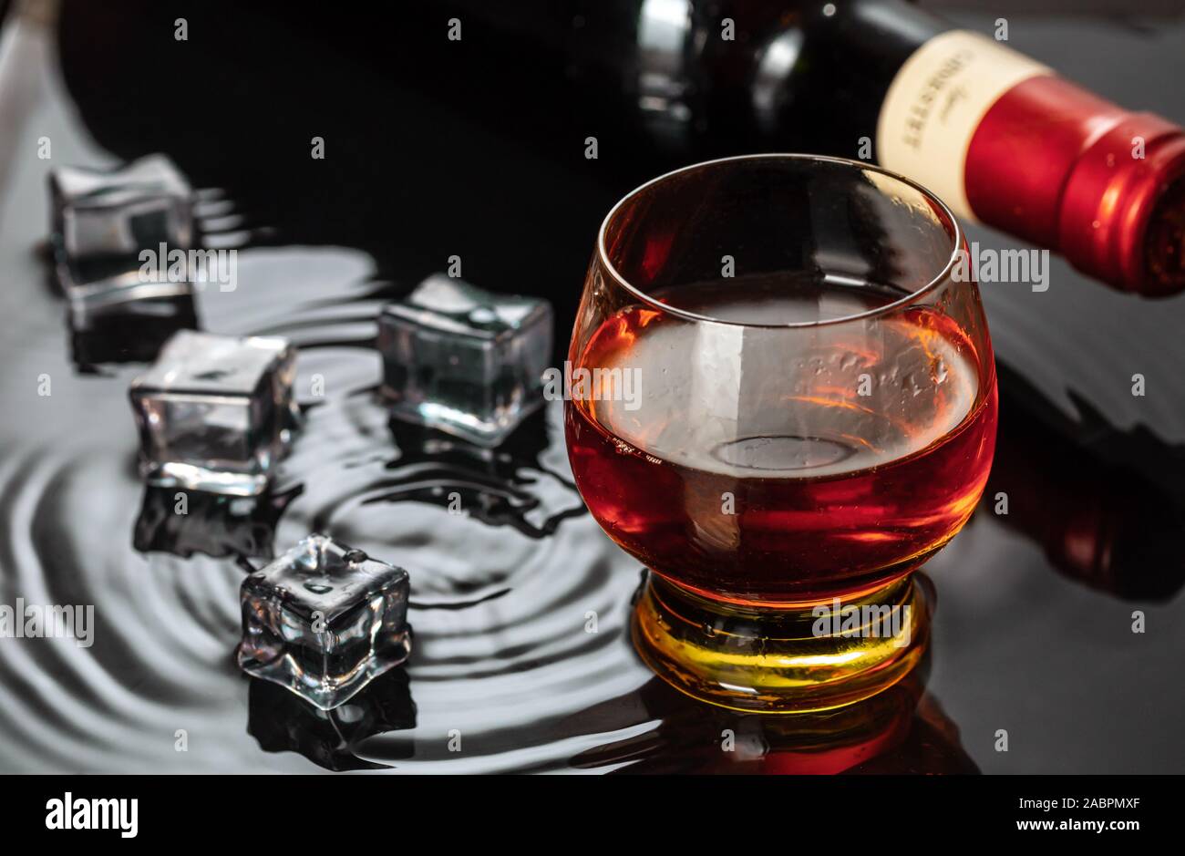 Bottle of red wine with wineglass. Water splash and droplet on the ...