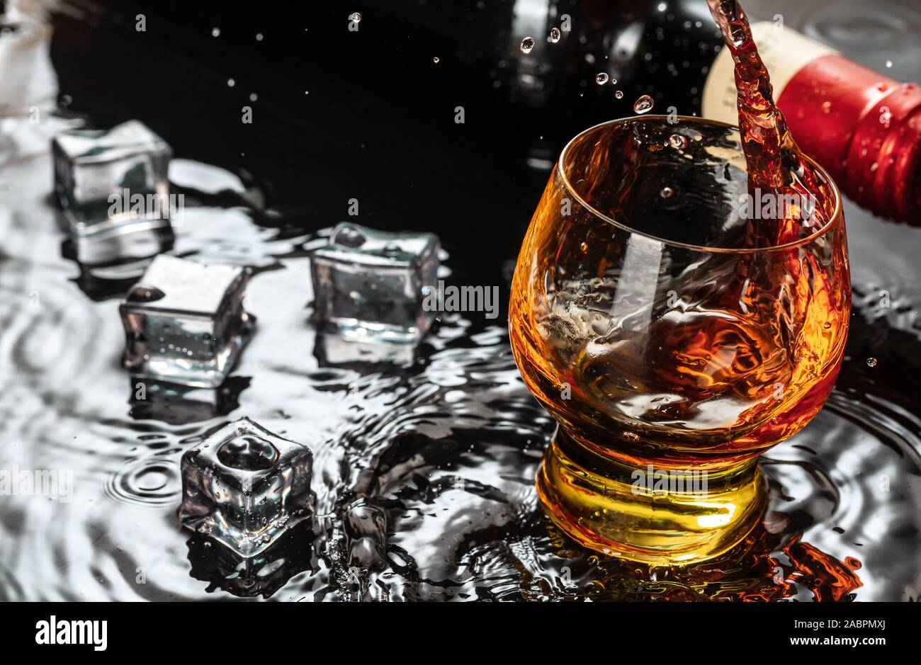 Bottle of red wine with wineglass. Water splash and droplet on the ...