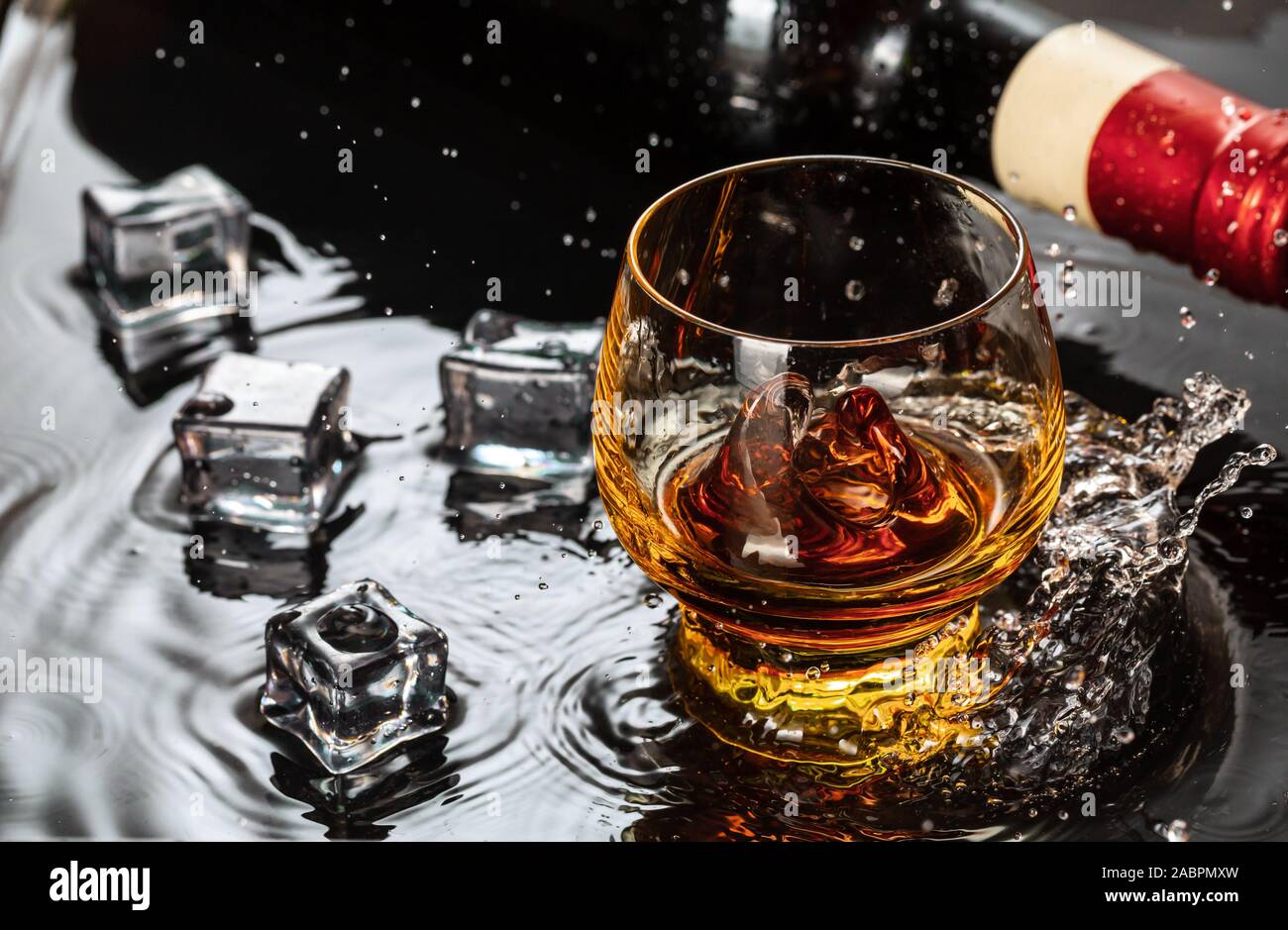 Bottle of red wine with wineglass. Water splash and droplet on the ...