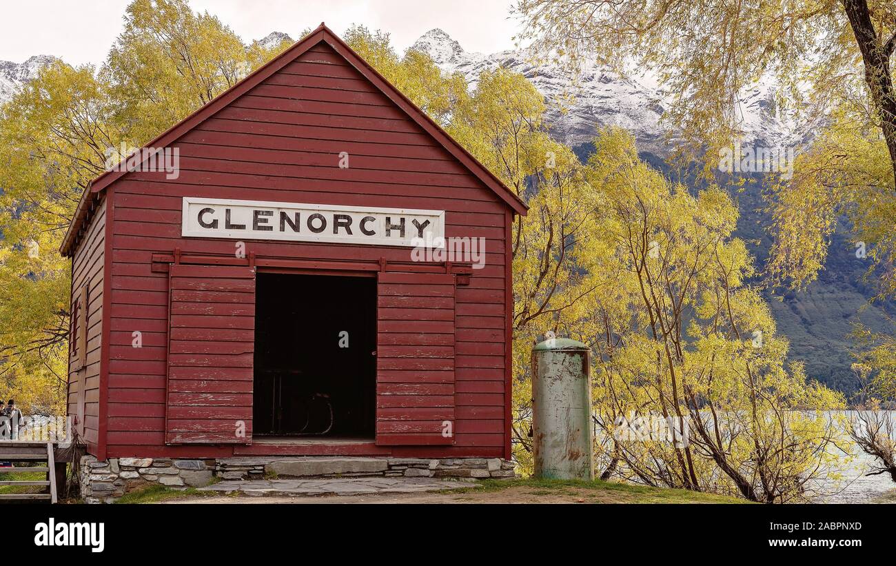 Old red hut on lake at Glenorchy in New Zealand in autumn with yellow ...