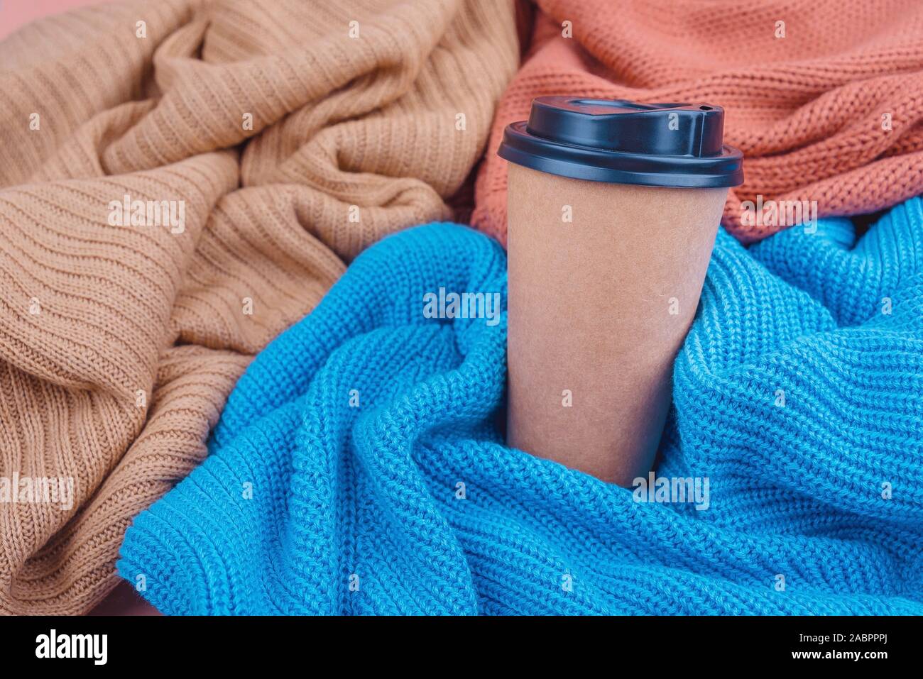 Coffee paper cup on colorful knitted blankets background, top view flat ...
