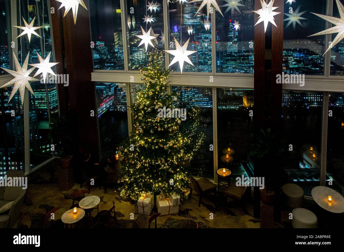 Gifts underneath a Christmas tree in the Shard with the City of London ...