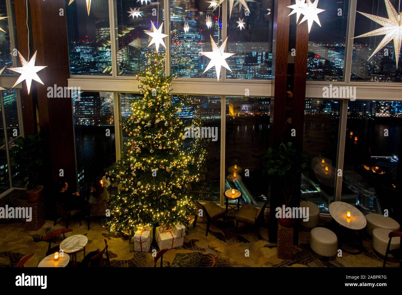 Gifts underneath a Christmas tree in the Shard with the City of London ...