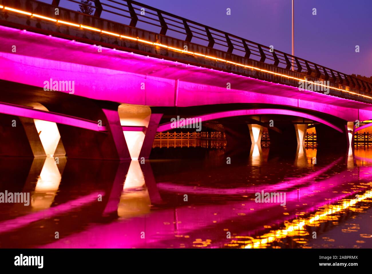 Pink light illuminated bridge water reflected at night, Hefei, China ...