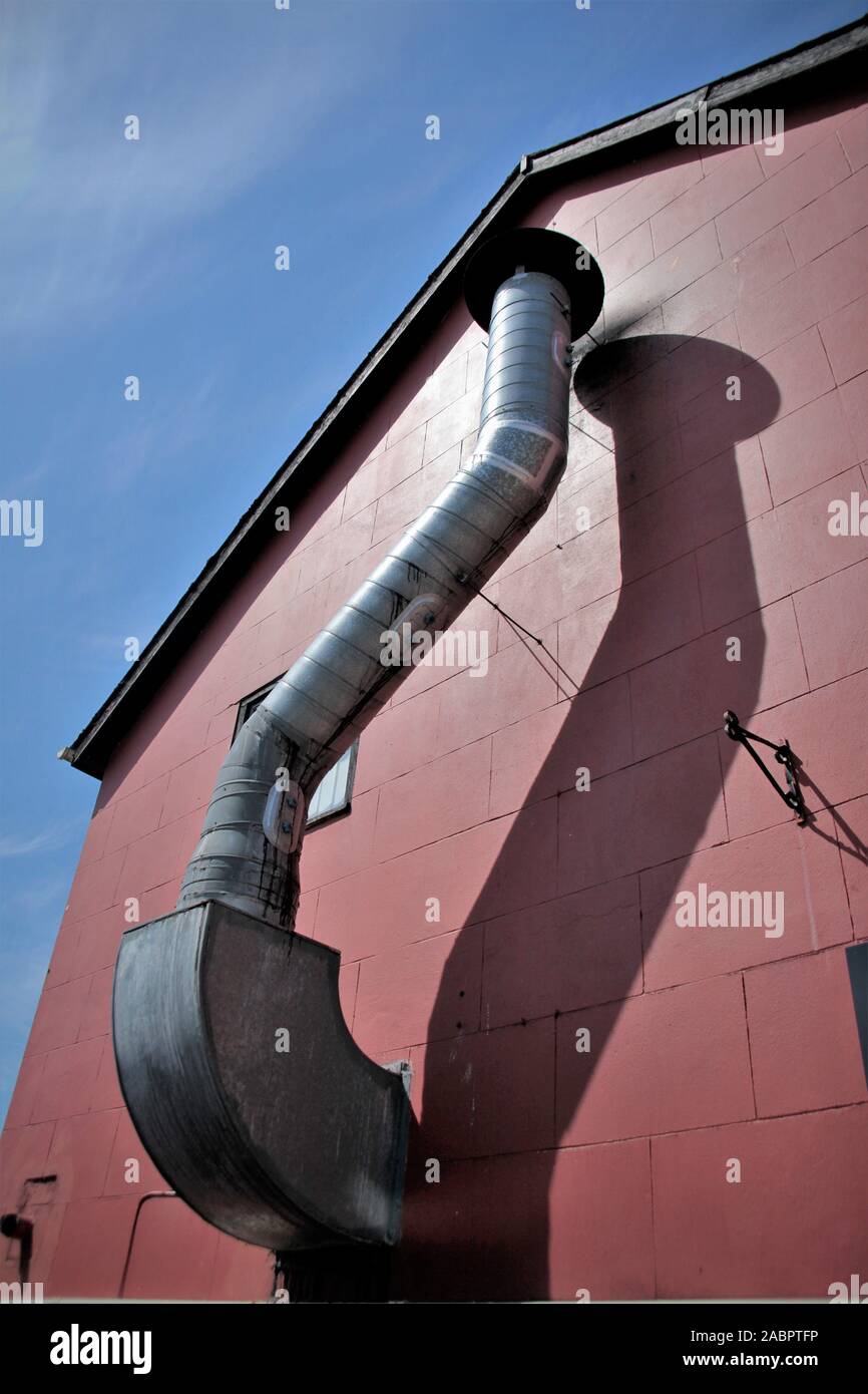 Exhaust pipe from heater on side of a building with shadow and color ...
