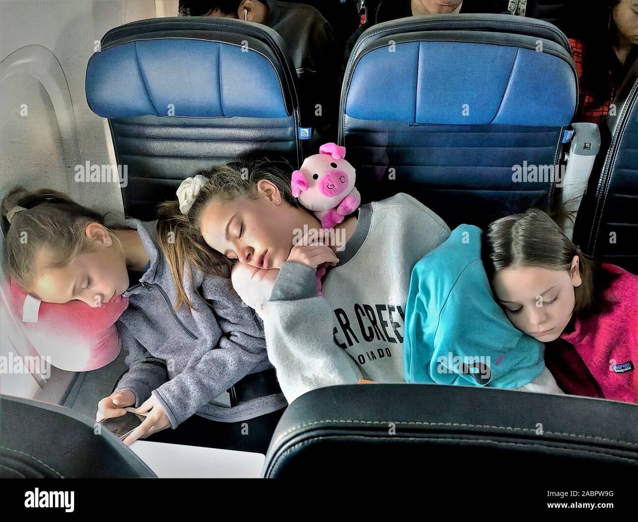 three 3 young girls sleeping on commercial airliner a long flight from ...
