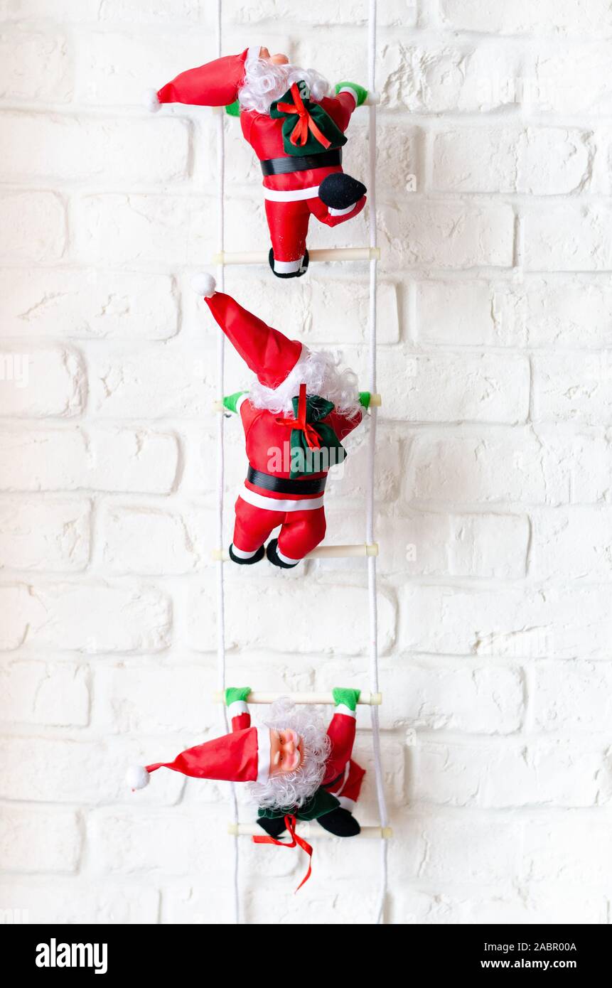 Climbing red santa claus on ladder agains white brick wall Stock Photo ...