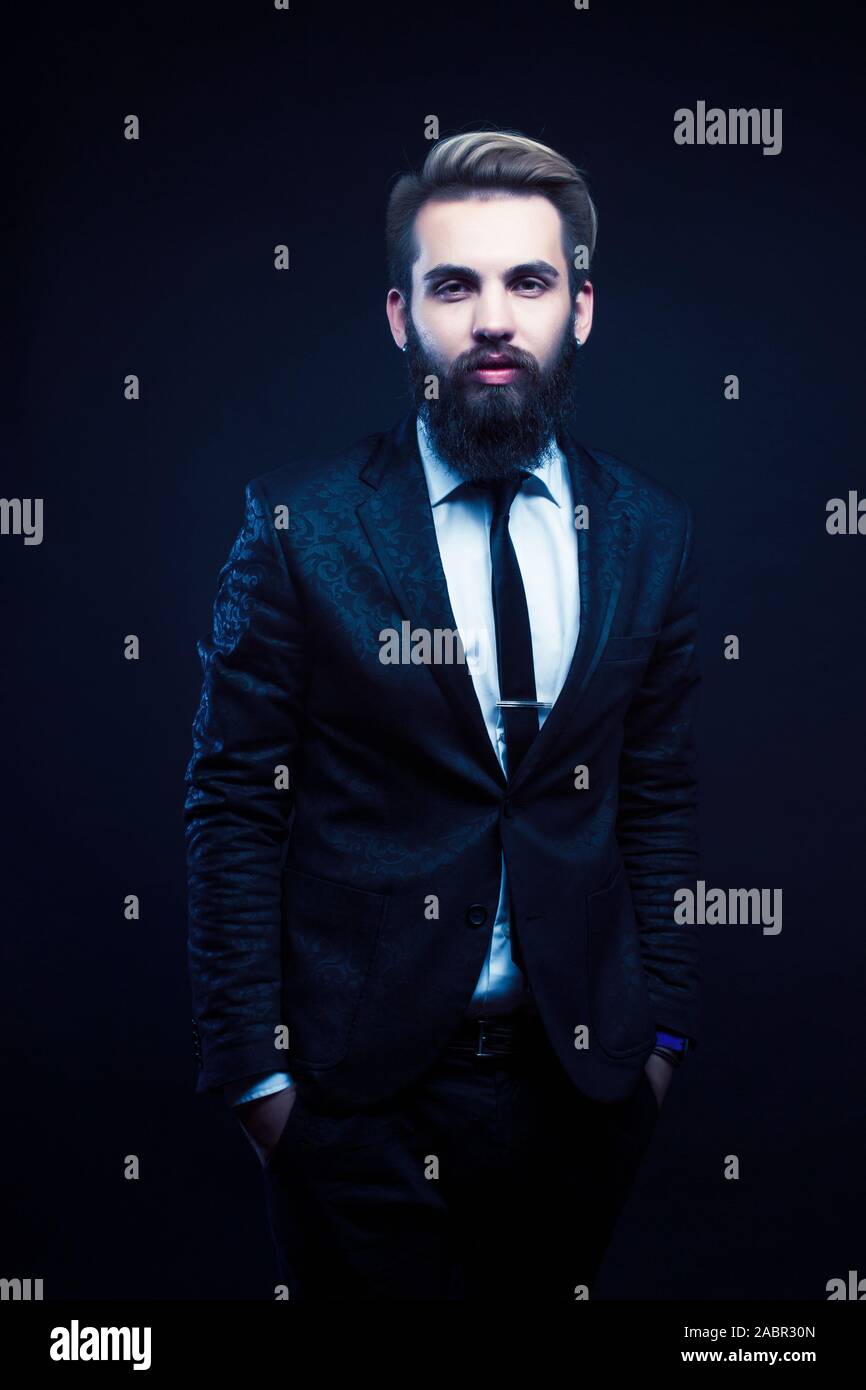 young pretty modern hipster business man with beard standing on black ...