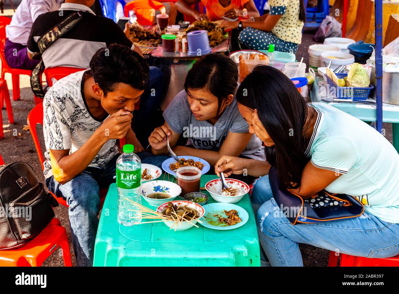 Young People Eating Street Food From A Stall In Downtown Yangon, Yangon ...